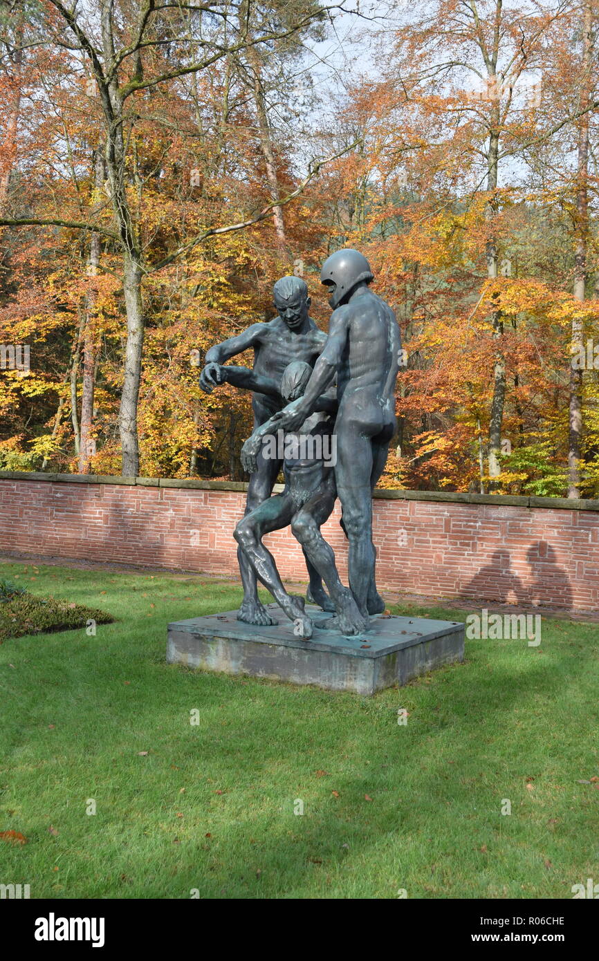 A bronze statue in Autumn in the War Cemetery in Reimsbach depicts two ...