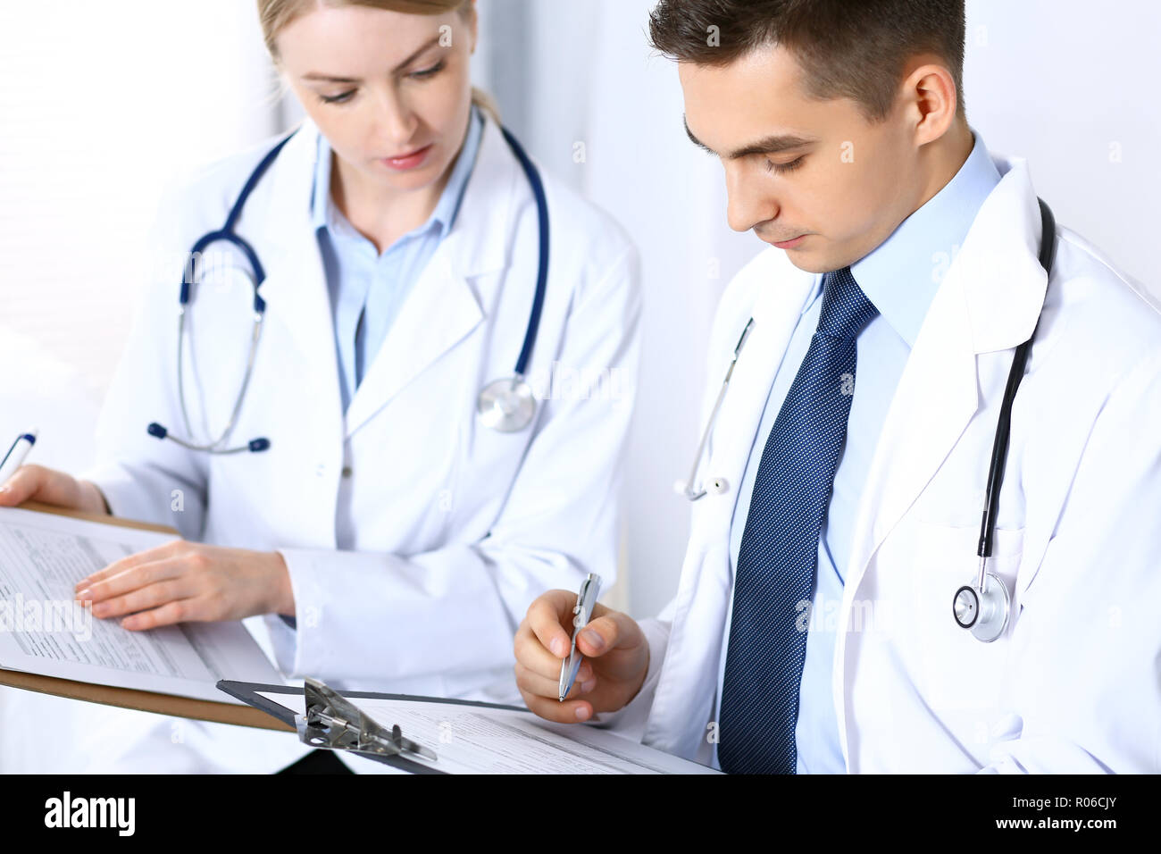 Doctors discussing medication records form or studying at medical ...