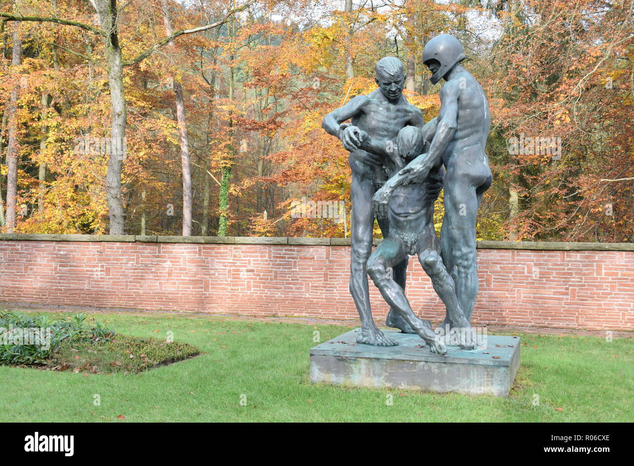 A bronze statue in Autumn in the War Cemetery in Reimsbach depicts two ...