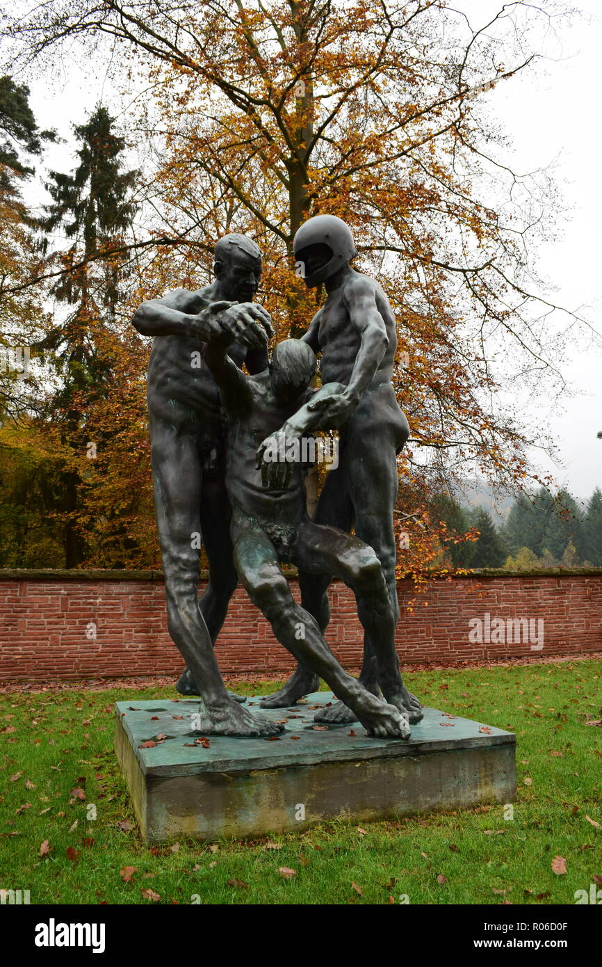 A bronze statue in Autumn in the War Cemetery in Reimsbach depicts two ...