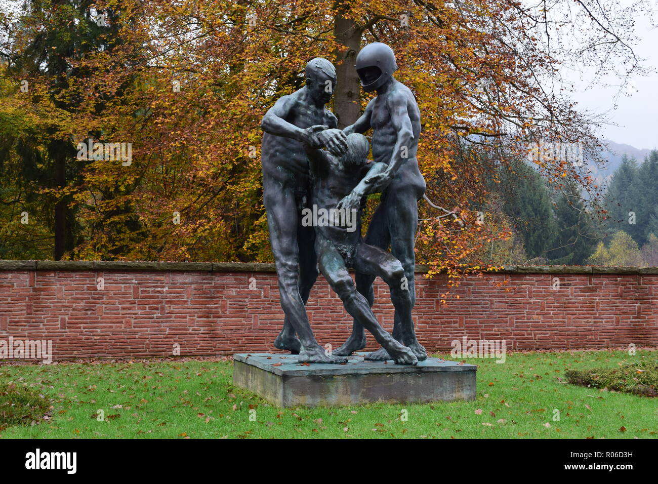 A bronze statue in Autumn in the War Cemetery in Reimsbach depicts two ...