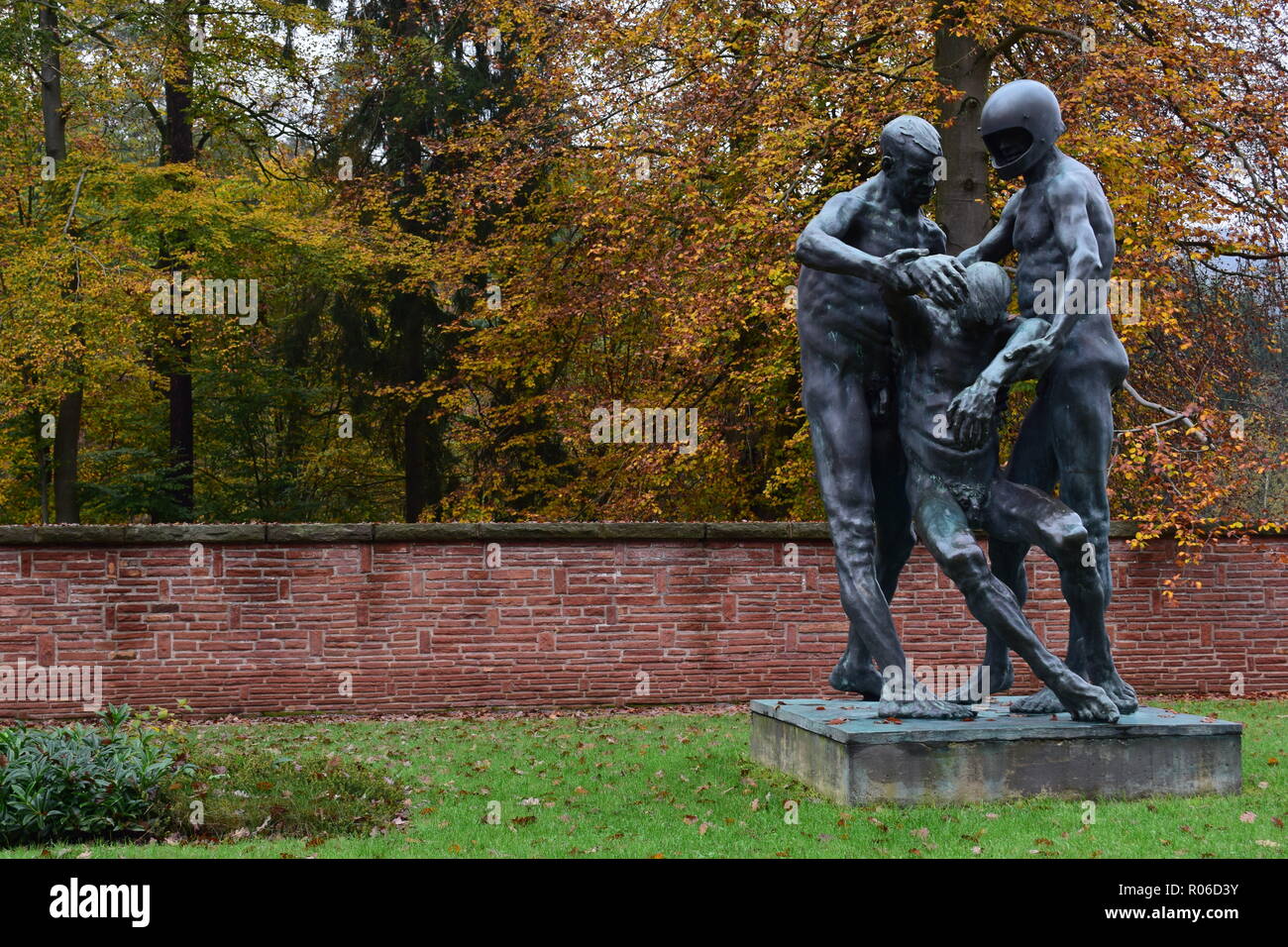 A bronze statue in Autumn in the War Cemetery in Reimsbach depicts two ...