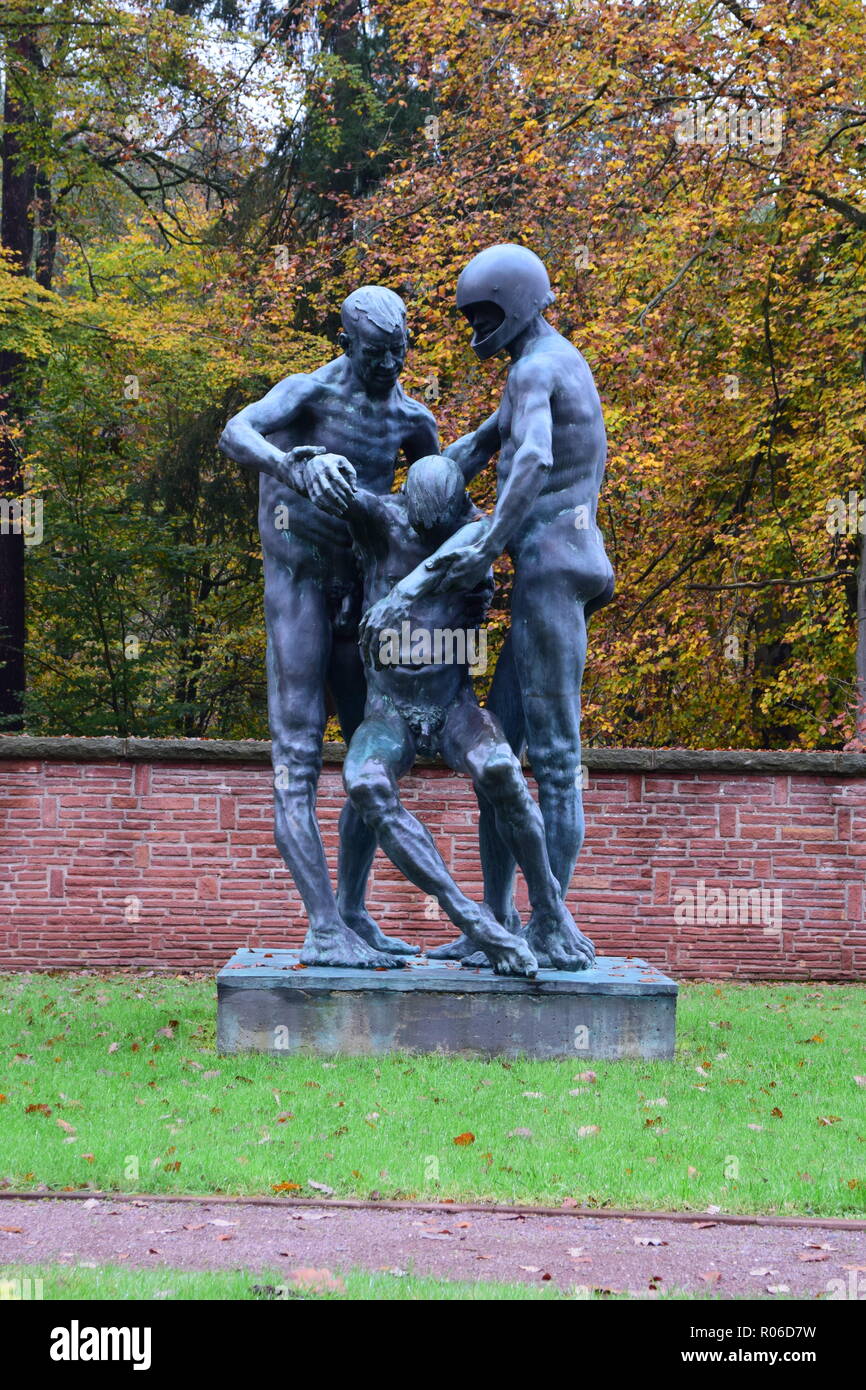 A bronze statue in Autumn in the War Cemetery in Reimsbach depicts two ...