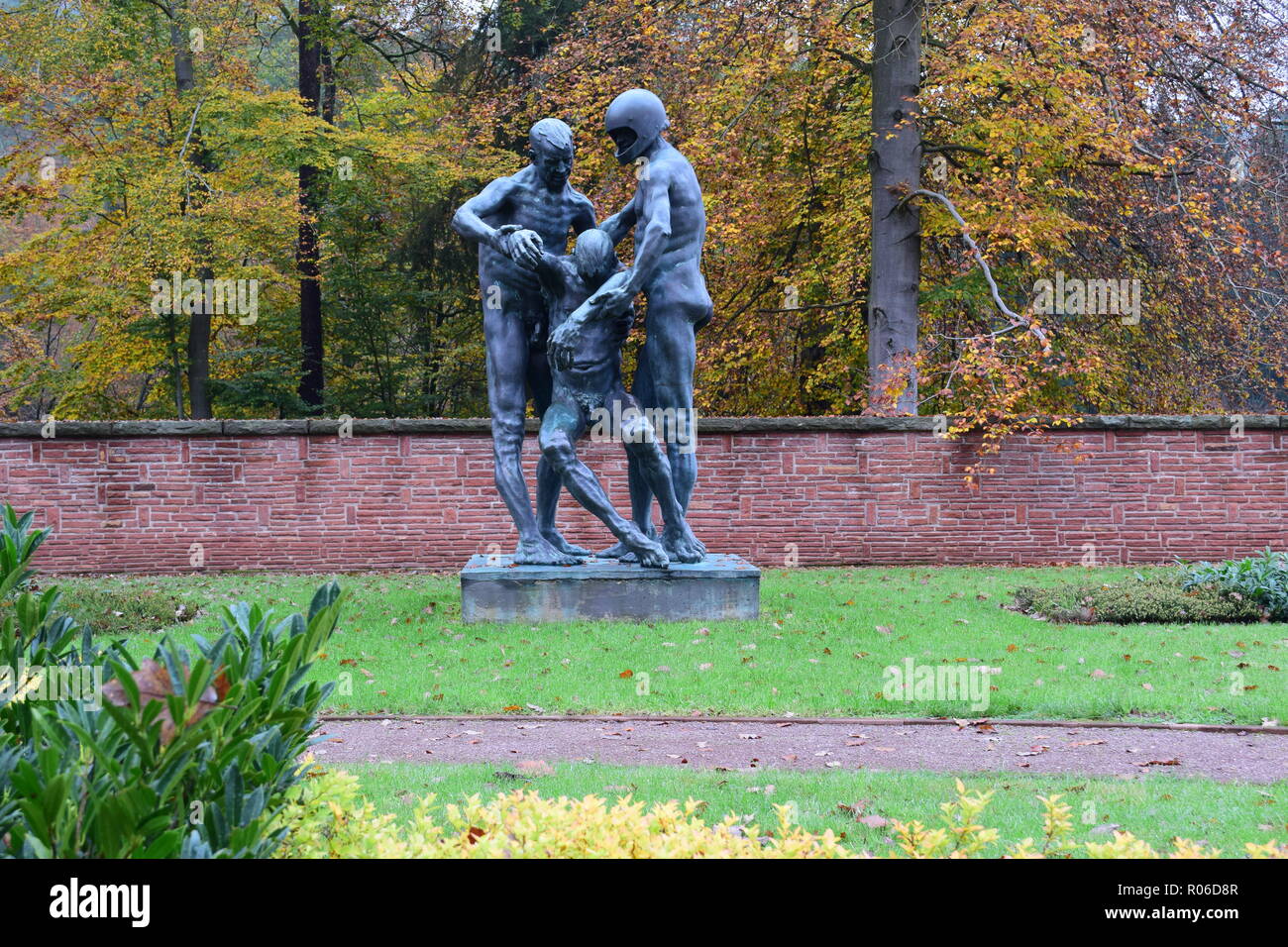 A bronze statue in Autumn in the War Cemetery in Reimsbach depicts two ...