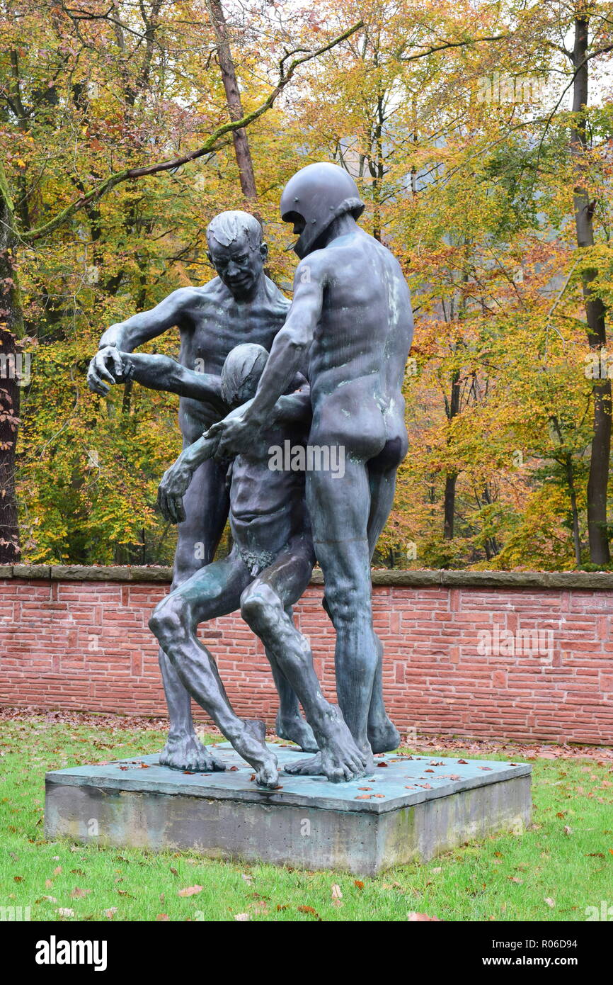 A bronze statue in Autumn in the War Cemetery in Reimsbach depicts two ...