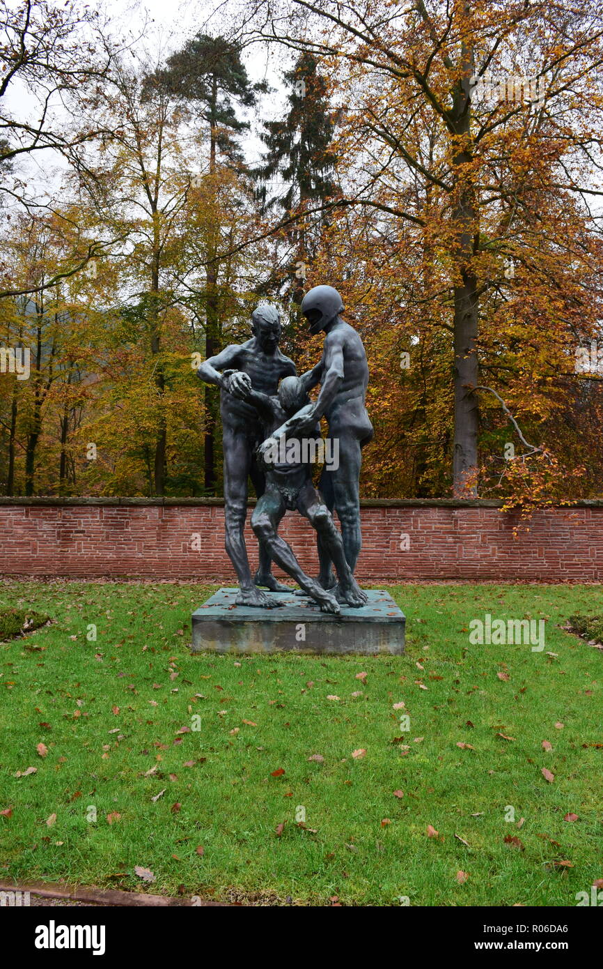 A bronze statue in Autumn in the War Cemetery in Reimsbach depicts two ...