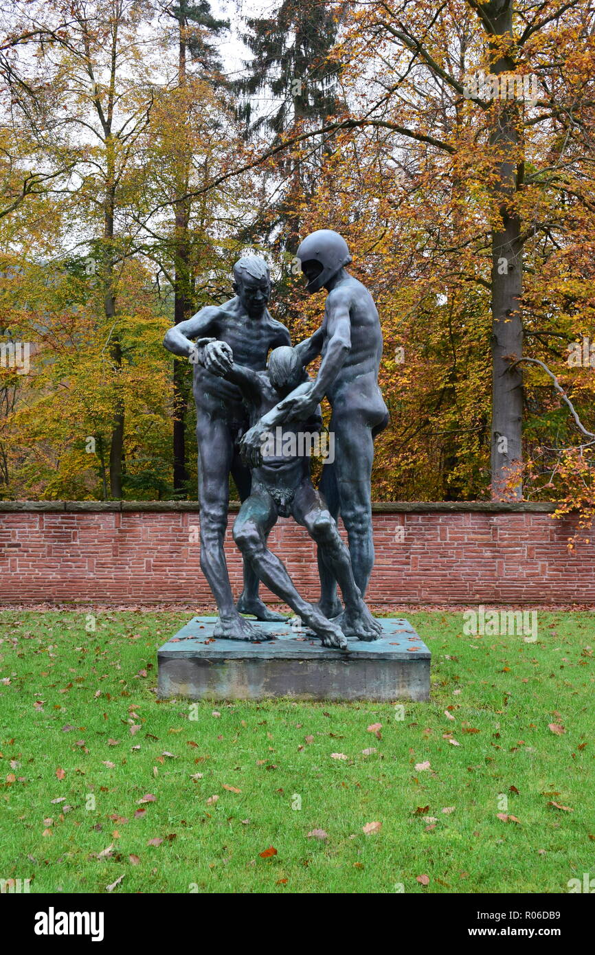 A bronze statue in Autumn in the War Cemetery in Reimsbach depicts two ...