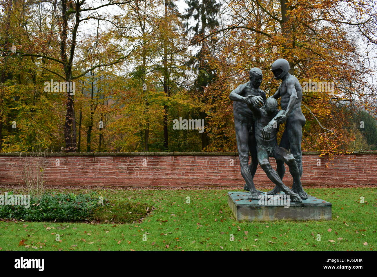 A bronze statue in Autumn in the War Cemetery in Reimsbach depicts two ...