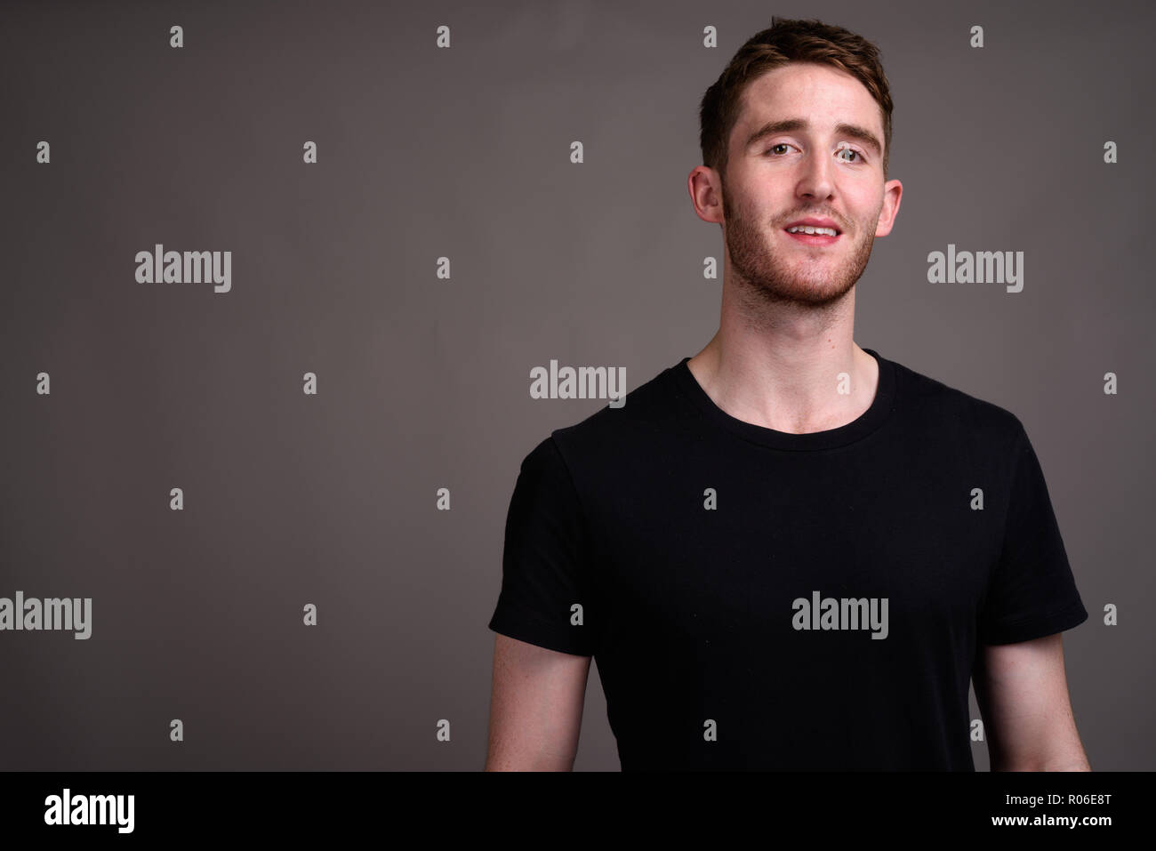 Portrait of young handsome man against gray background Stock Photo - Alamy