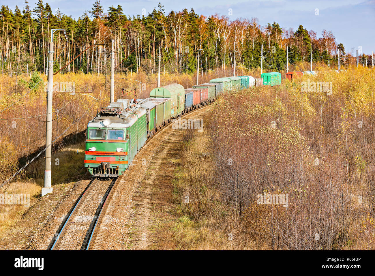 Long freight train approaches to the station at autumn day time Stock ...
