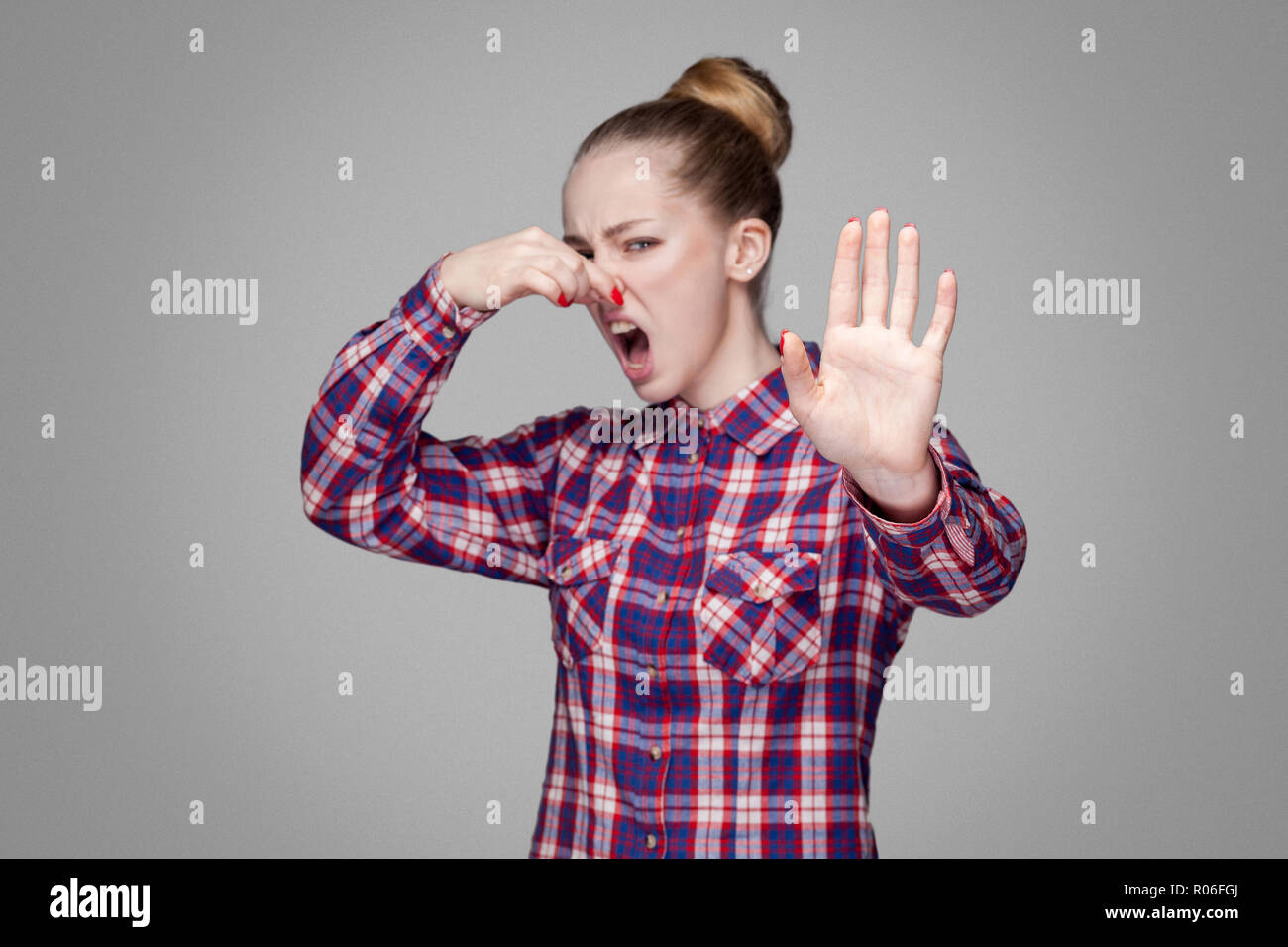 angry blonde girl in red, pink checkered shirt, collected bun hairstyle ...