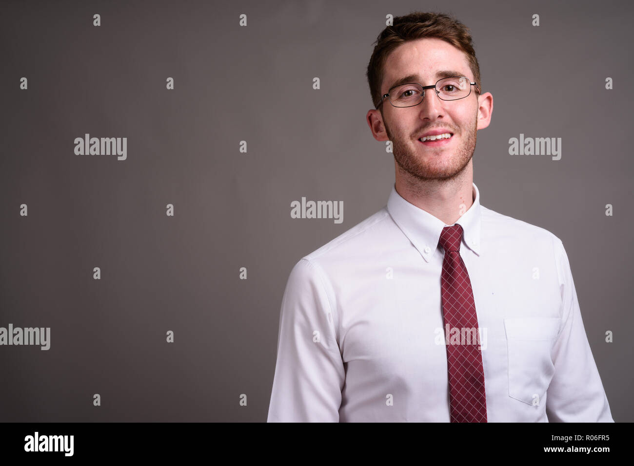 Young handsome businessman wearing eyeglasses against gray backg Stock ...