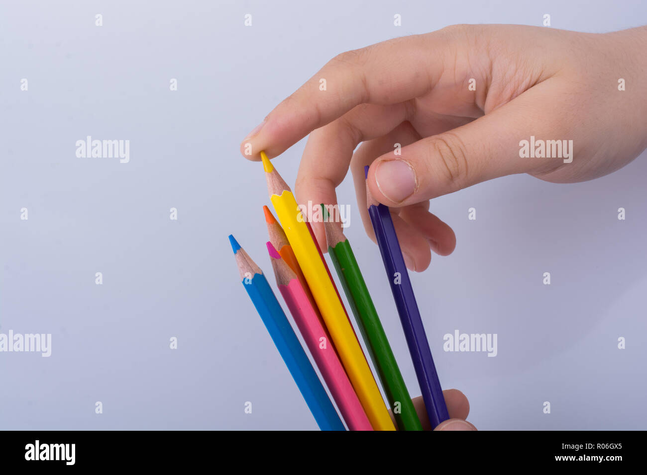 Hand holding color Pencils placed on a white background Stock Photo - Alamy