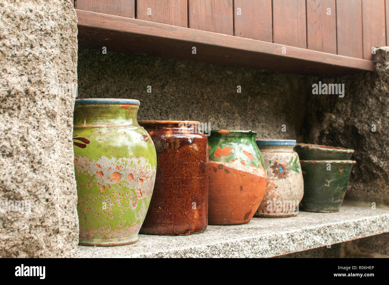 Various ceramic pots next to each other in a row in stone niche on ...