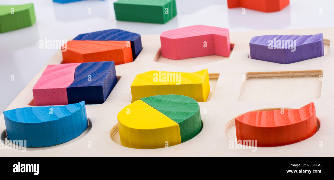 Colorful wooden pieces of a logic puzzle in hand Stock Photo - Alamy