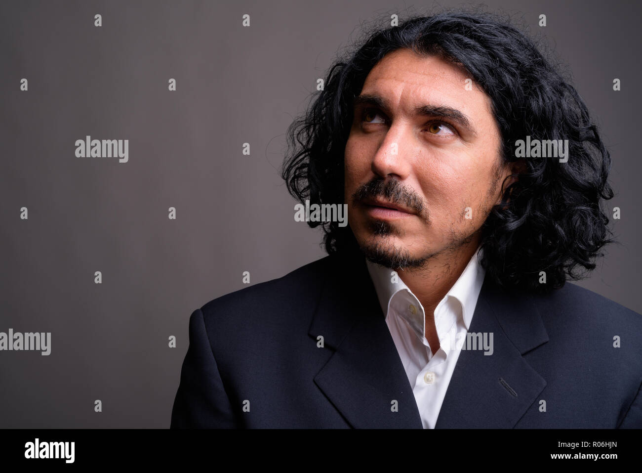 Handsome businessman with mustache wearing suit against gray bac Stock ...