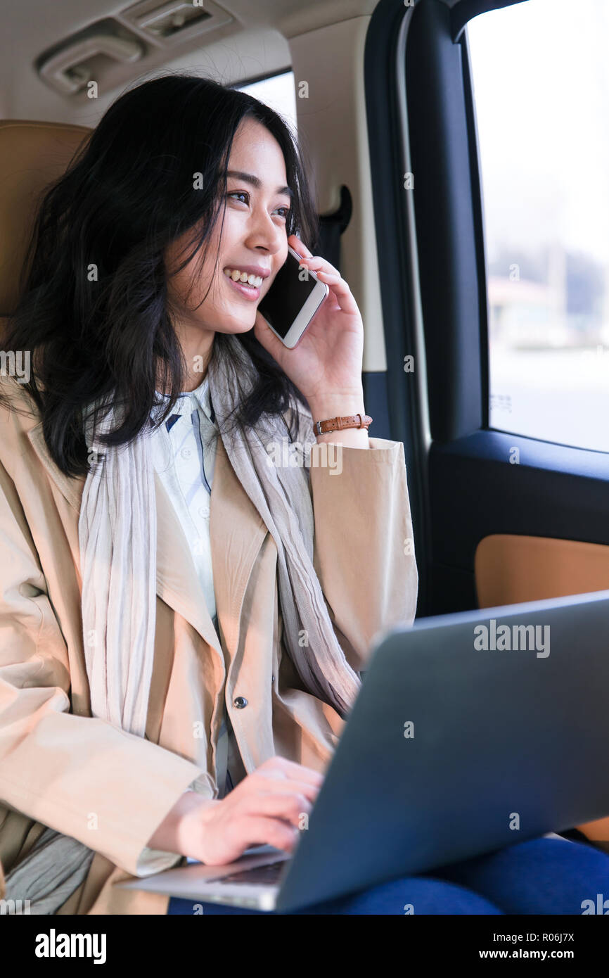 Business woman sitting in the back seat Stock Photo - Alamy