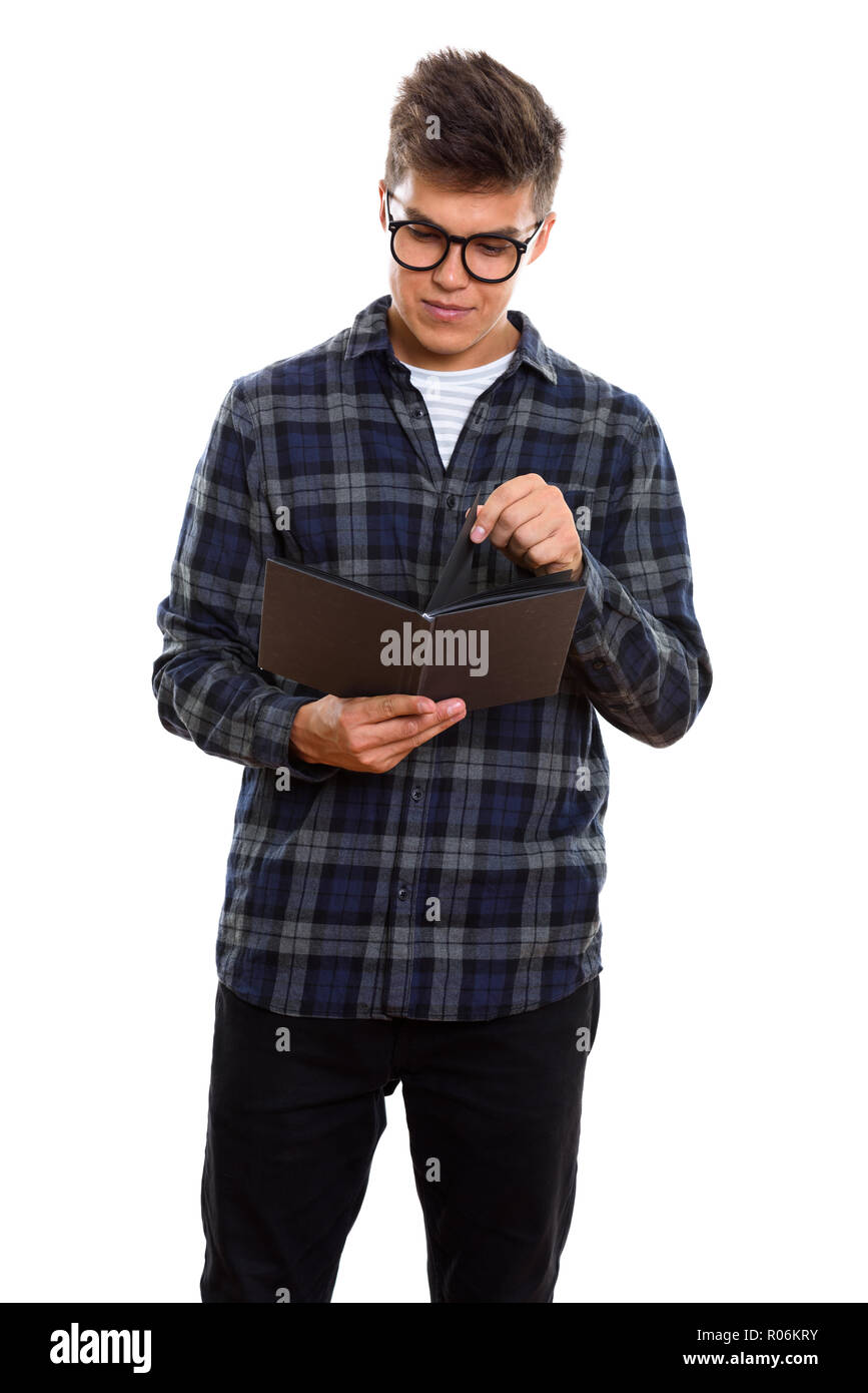 Studio shot of young handsome man standing while reading book Stock ...