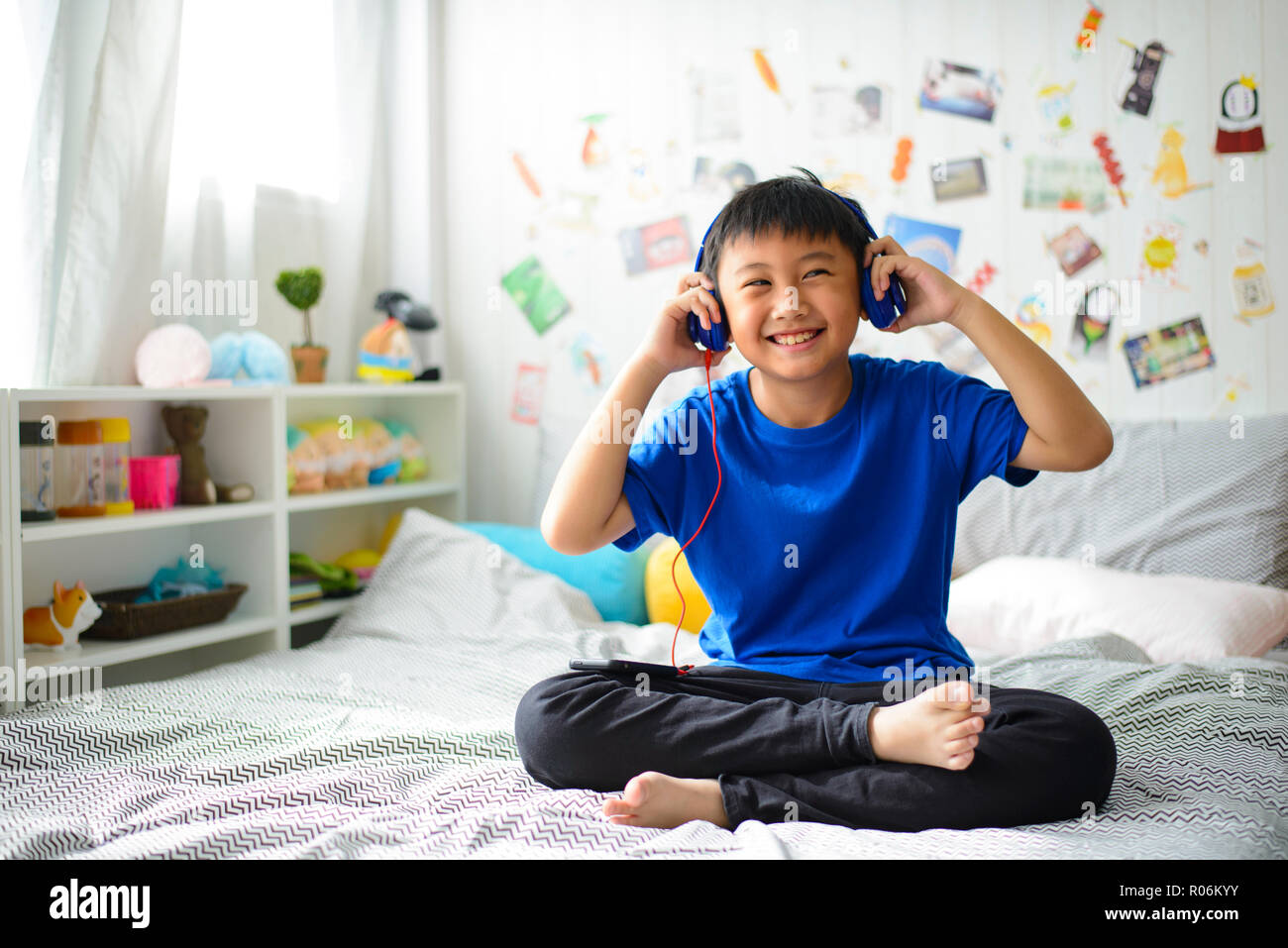 Little asian boy using headphones and smiling happy while listening ...