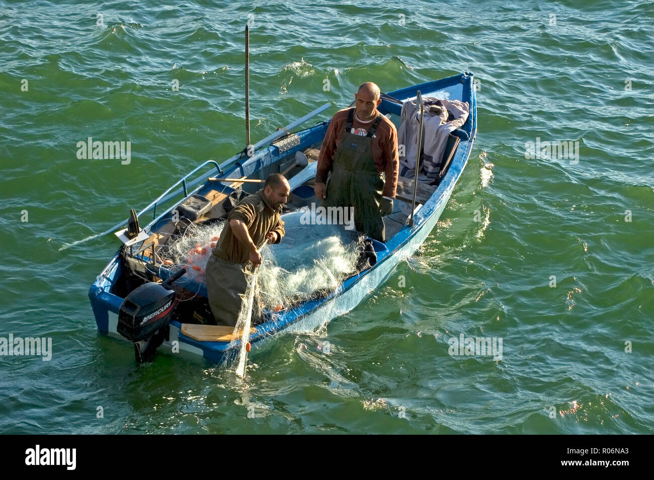 Fishing boat and fishermen on the Sea of Galilee, Israel Stock Photo ...