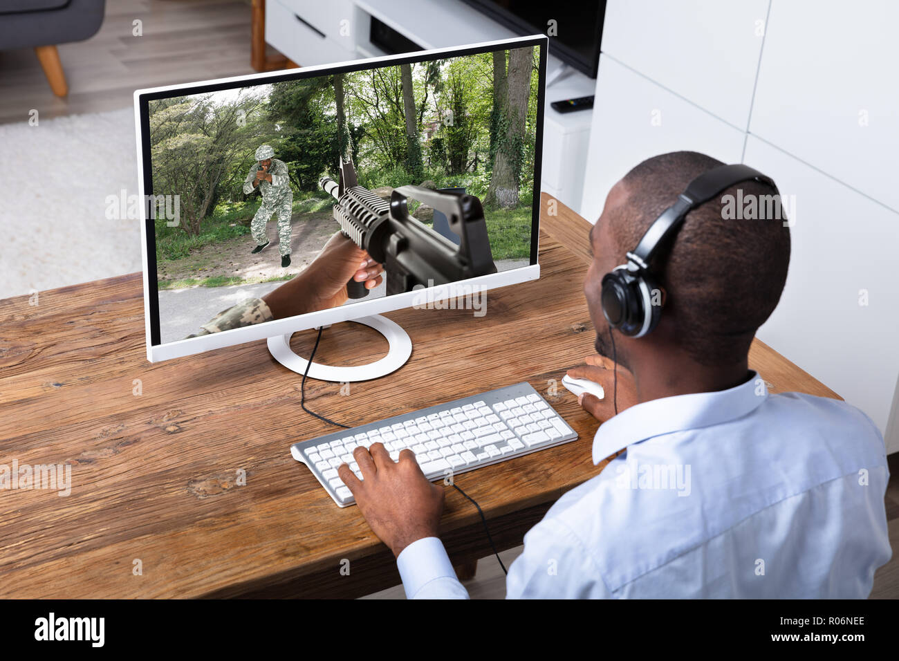 Young African Man Playing Action Game On Computer Over Wooden Desk ...