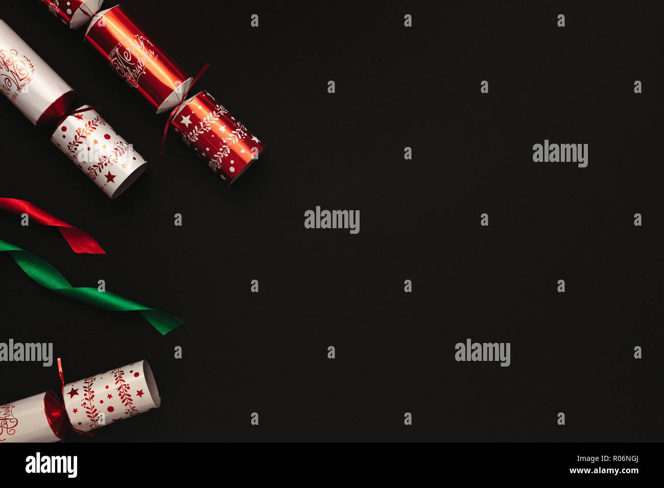 Christmas crackers with ribbons placed on black background with copy ...