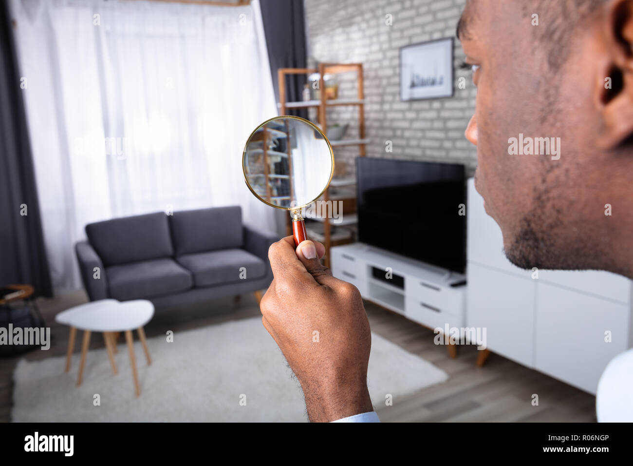 Man Searching In The House With Magnifying Glass Stock Photo - Alamy