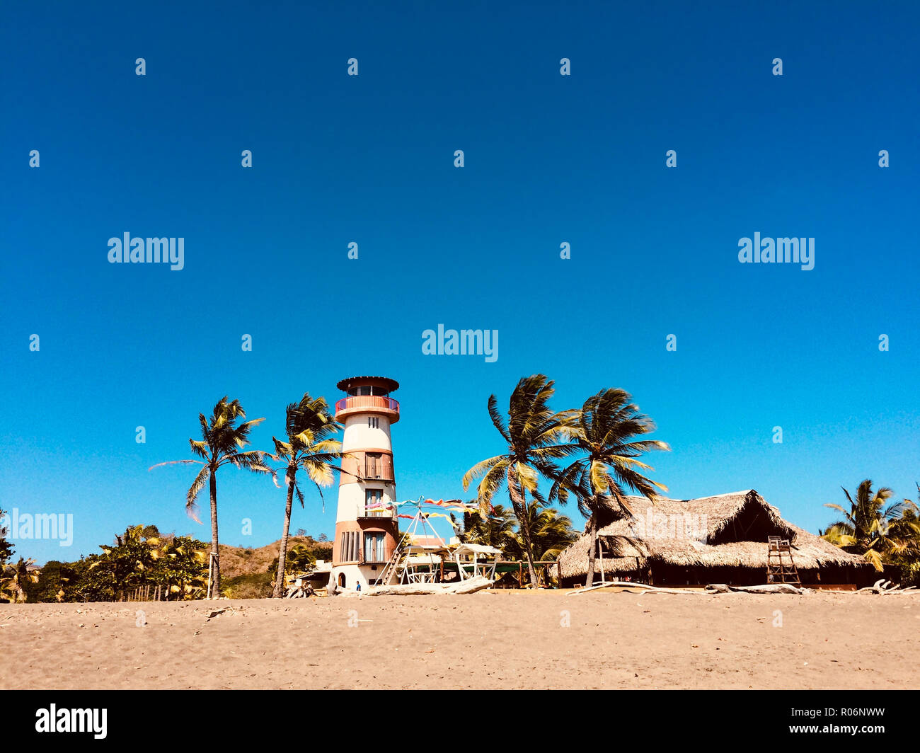 lighthose tower, hut, palm trees and houses at beach on sunny day Stock ...