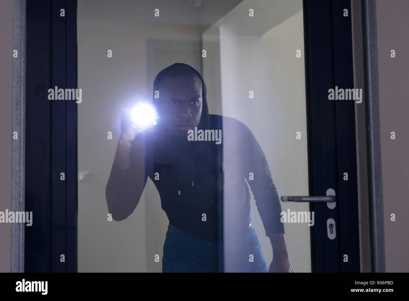 Burglar looking through glass door hi-res stock photography and images ...