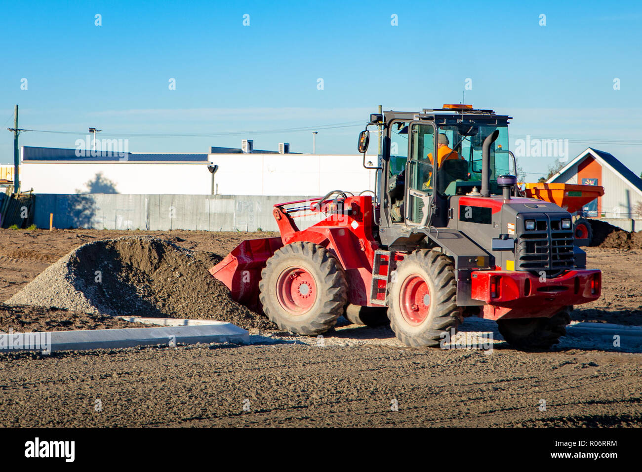 A red loader used at a building site to shift piles of gravel and dirt ...