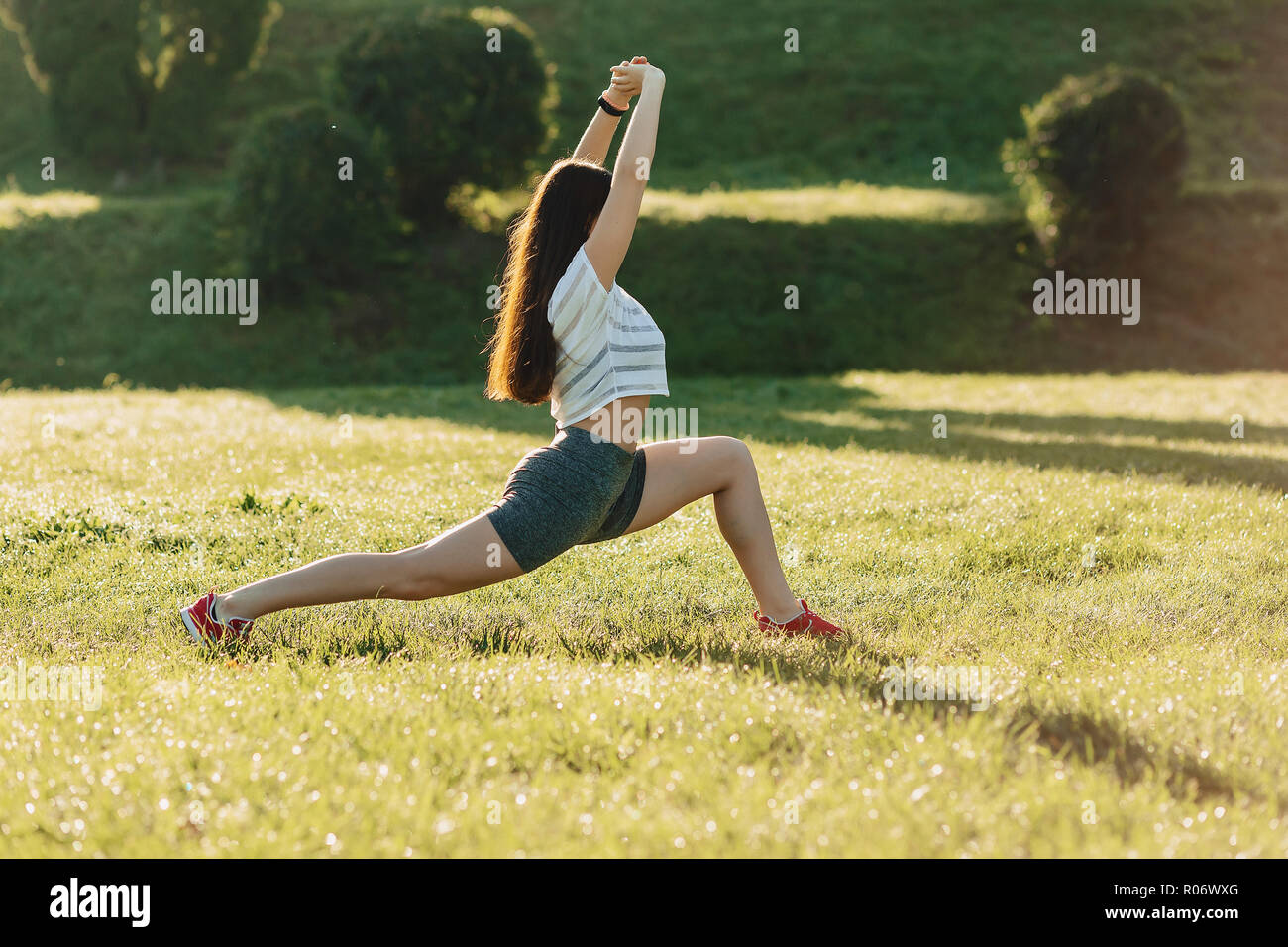 cozy fitness girl making morning stretching exercises outside on ...