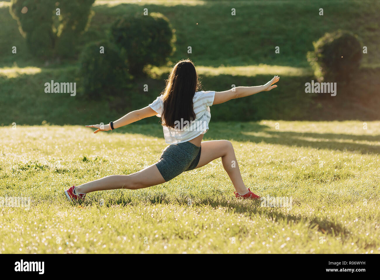 cozy fitness girl making morning stretching exercises outside on ...