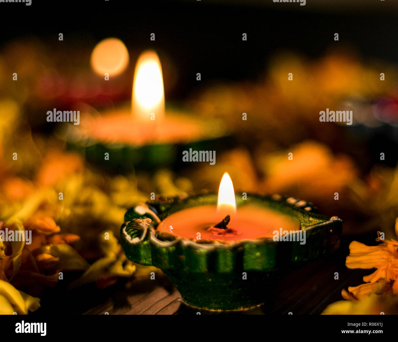 Lit diya arranged with flowers Stock Photo - Alamy