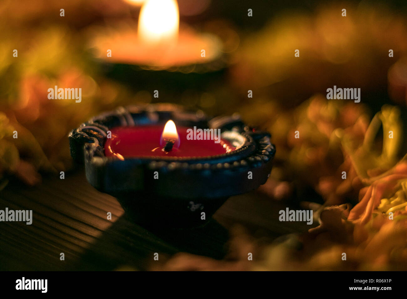 Lit diya arranged with flowers Stock Photo - Alamy