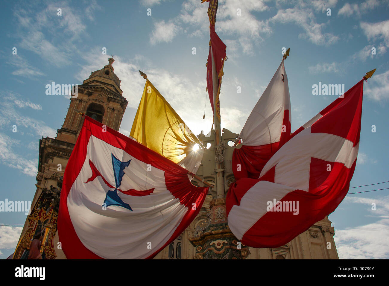 Sun light throuh waving red, yellow and white flags on festively ...
