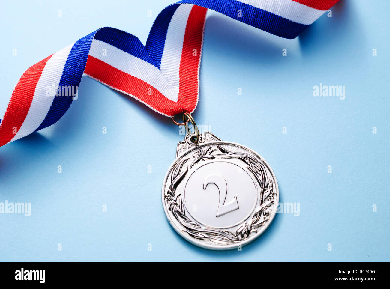 Silver medal 2 place with ribbon on a light blue background, the ...