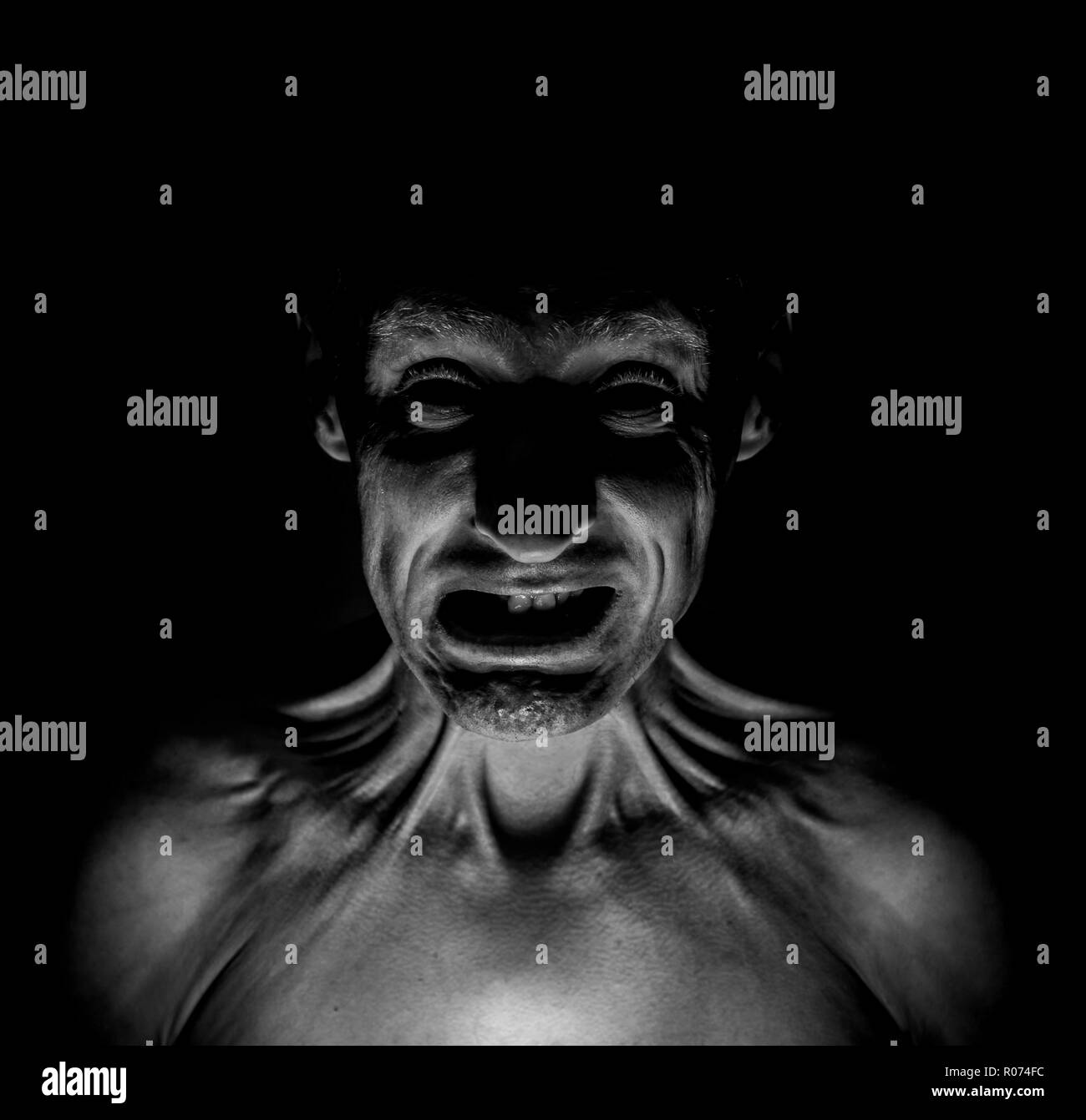 Stylish dark portrait of feared adult caucasian man who wrinkles his ...