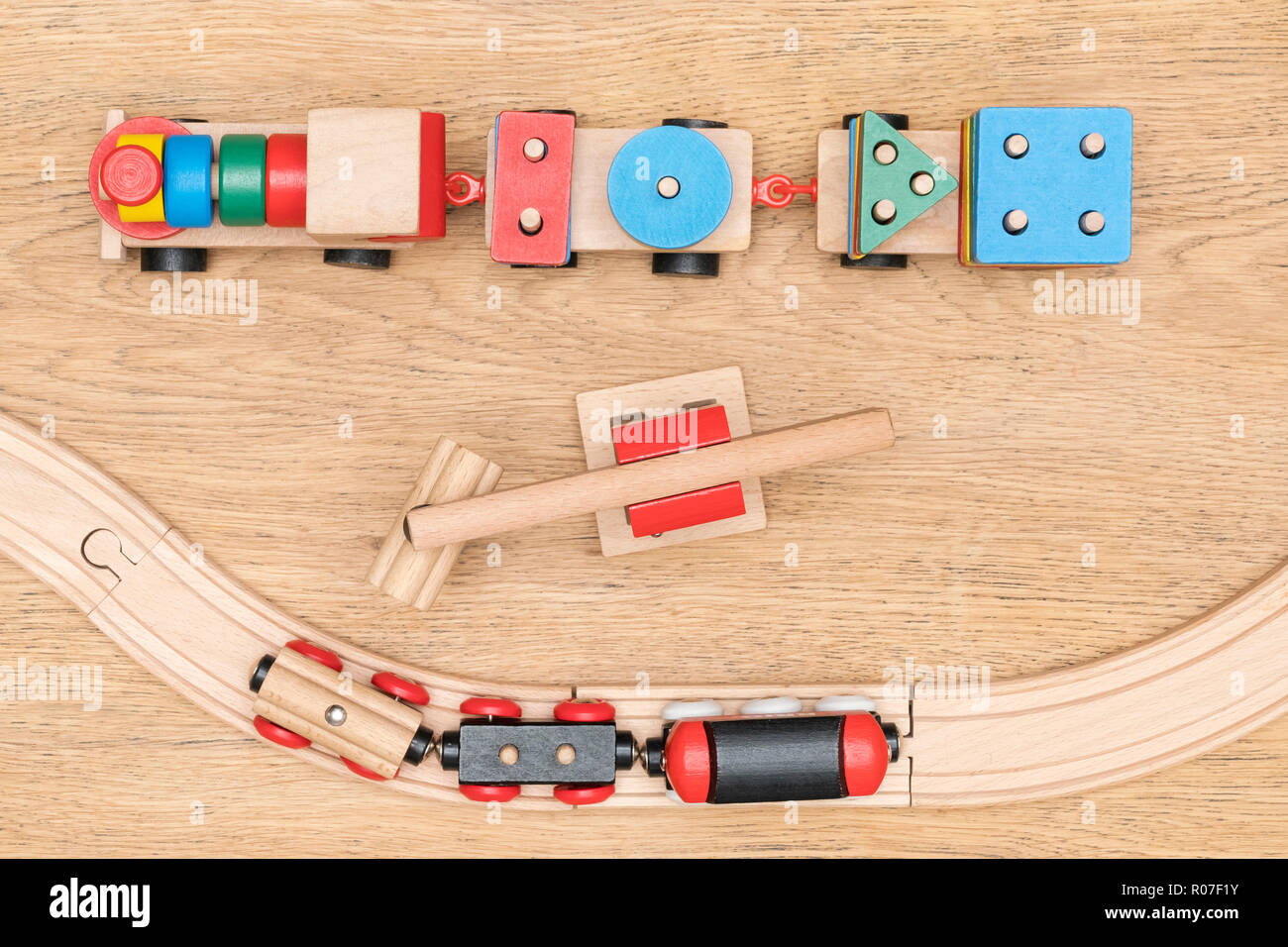 Toy wooden railway with train. Crane unloads cargo from the car. View ...