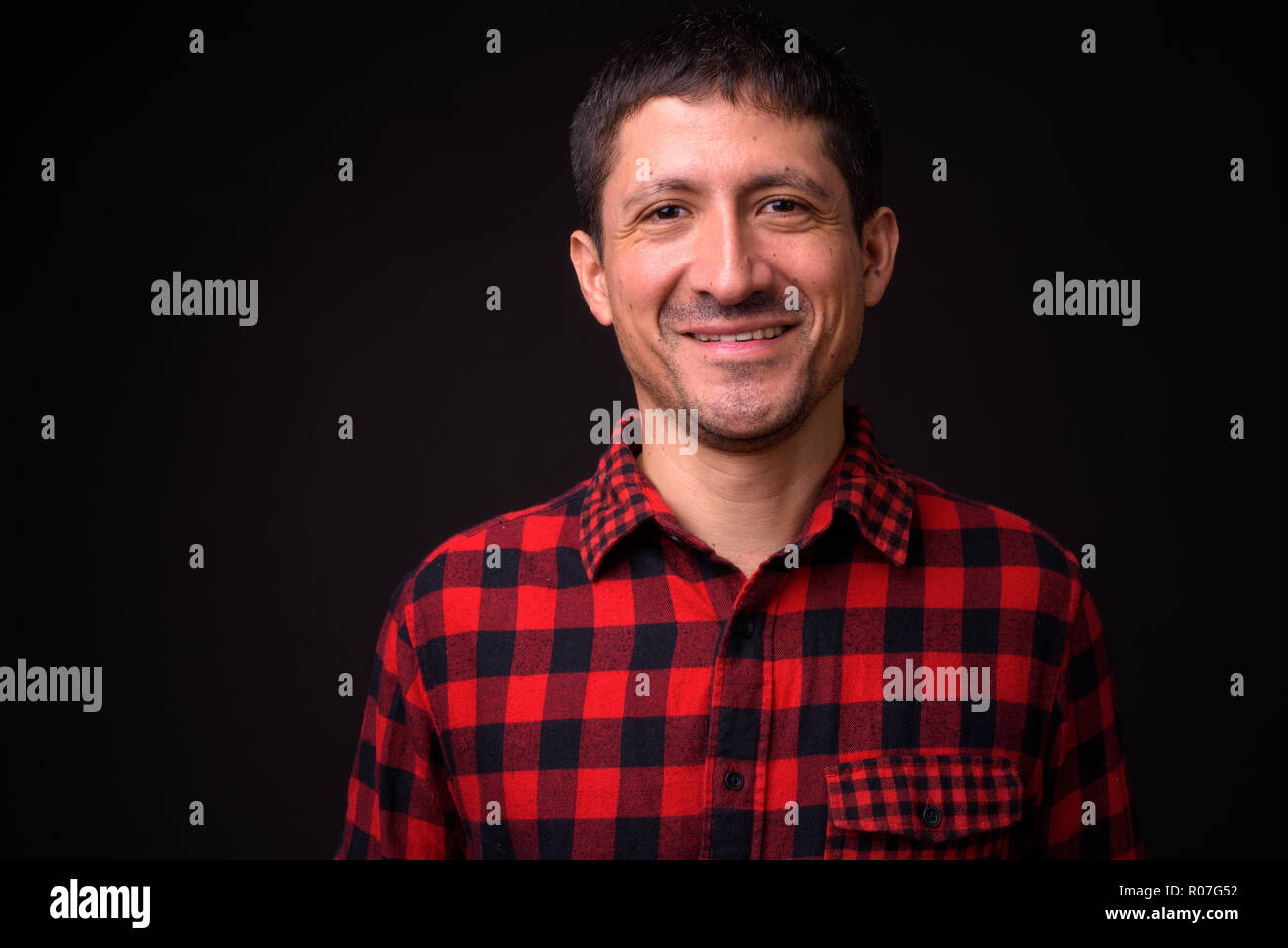Portrait of Hispanic man against black background Stock Photo - Alamy