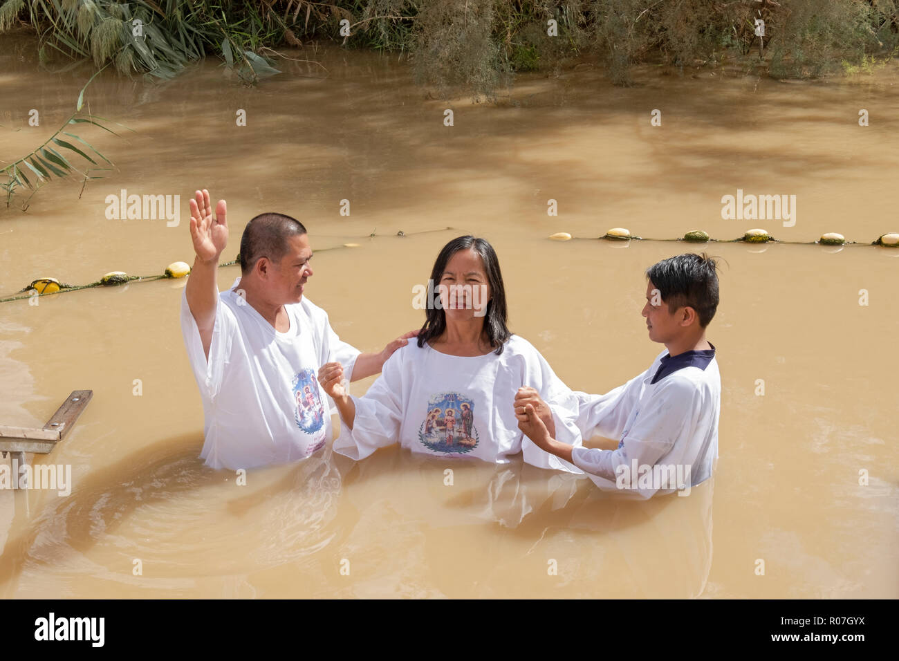 A visitor from the Philippines gets baptized in the Jordan River where ...