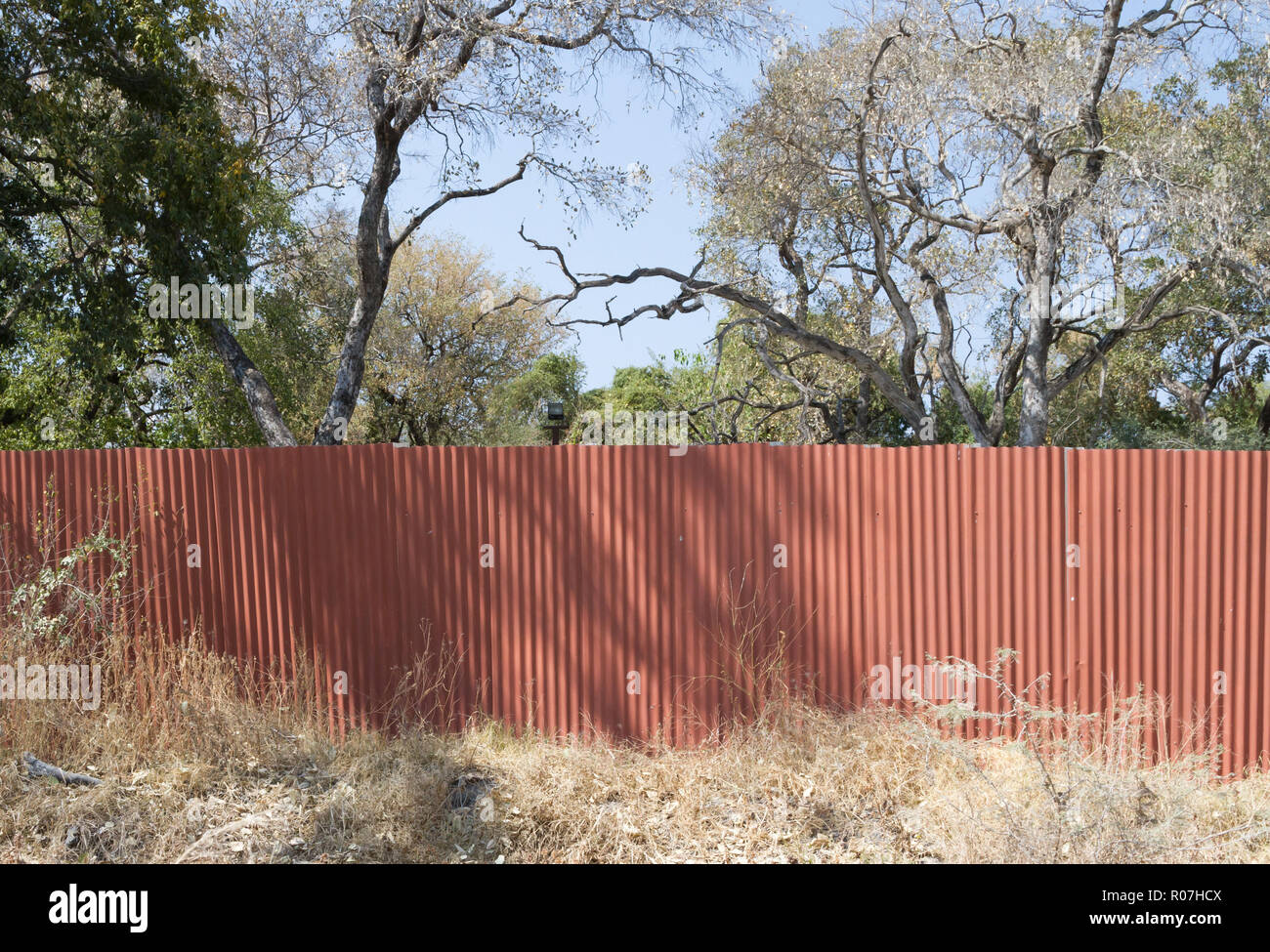 Red metal fence, protecting the property in Botswana Stock Photo - Alamy