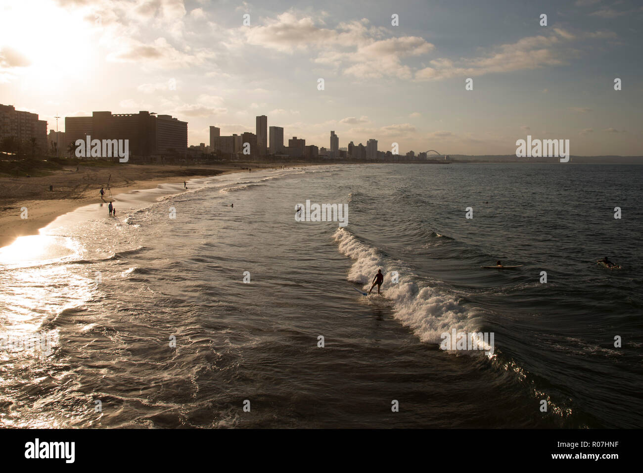 People surf and swim on the beach front in Durban, South Africa Stock ...