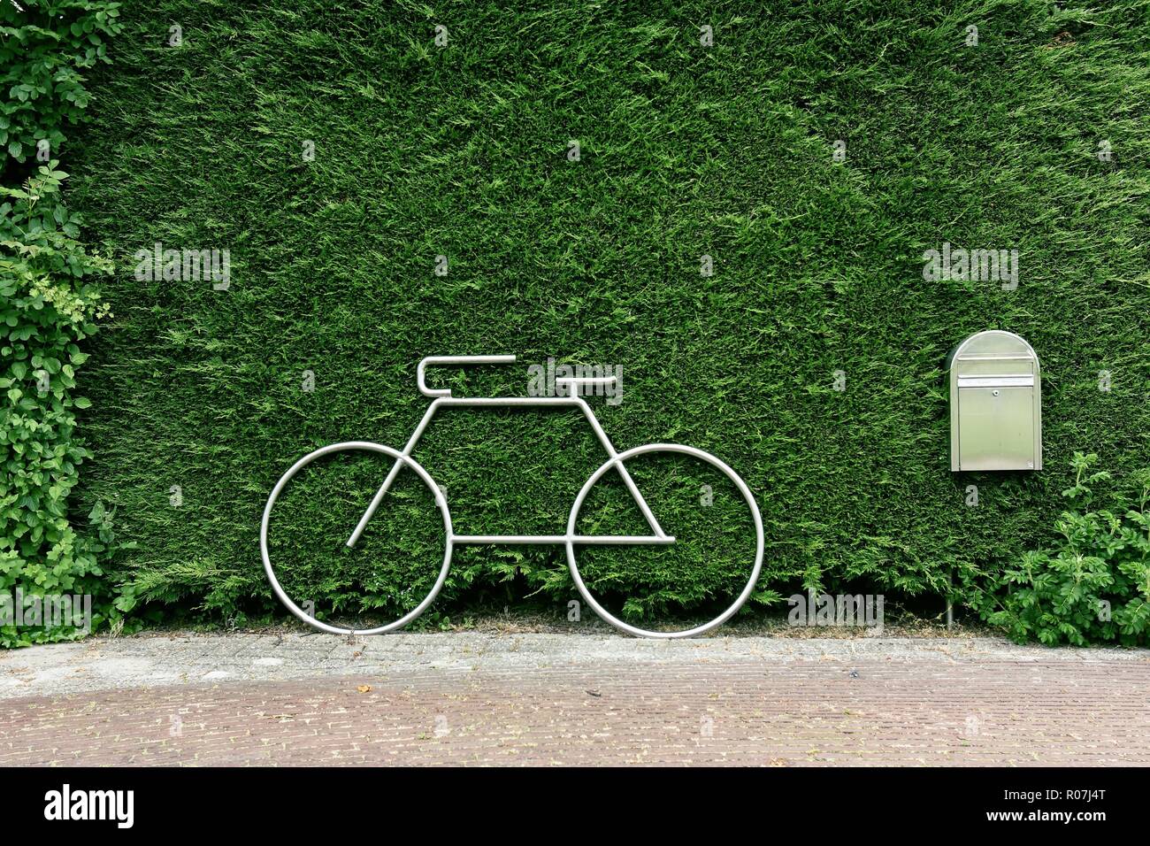 Stainless steel bicycle and mailbox against green hedge Stock Photo - Alamy
