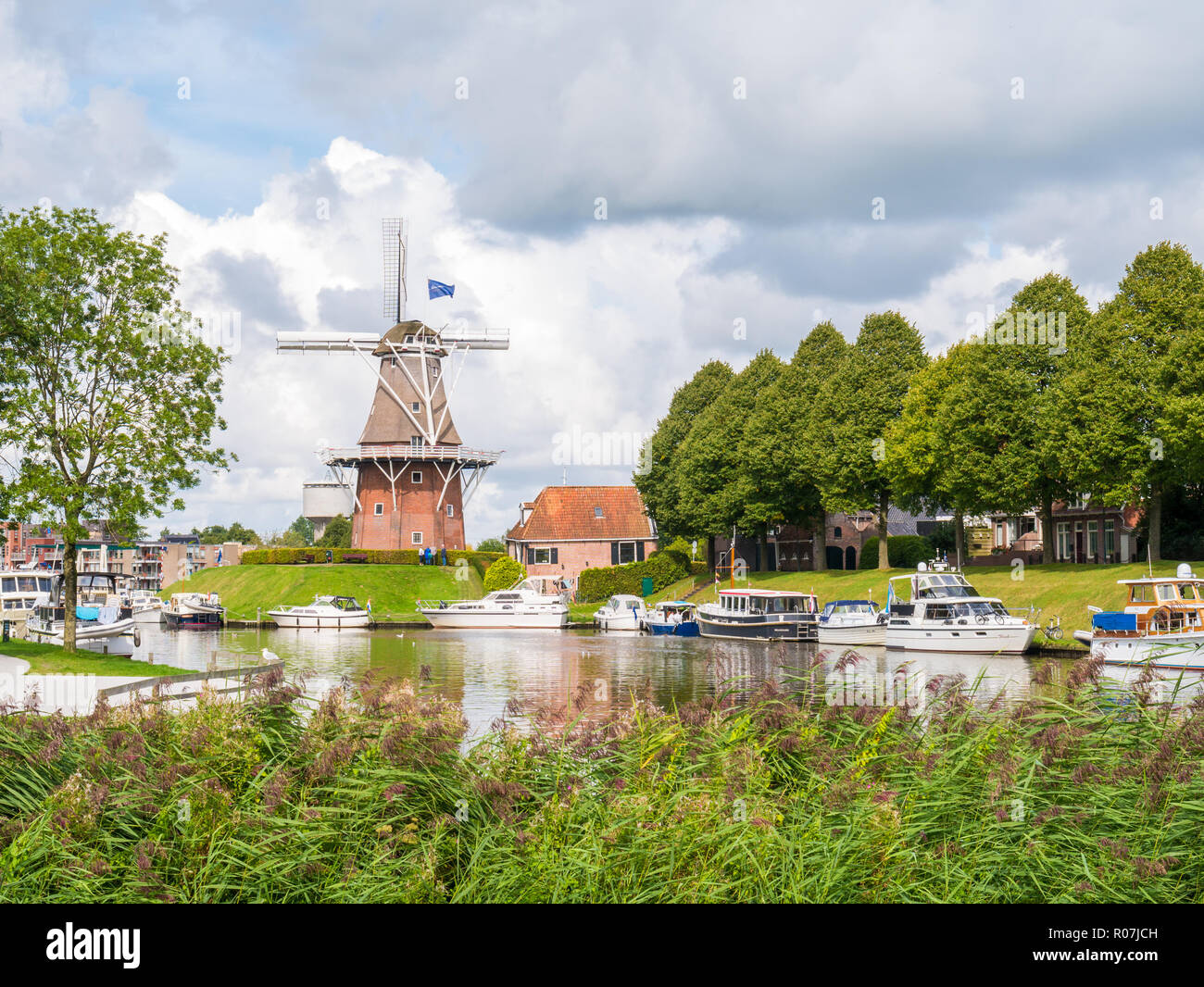 Motorboats on canal and windmill on fortifications of historic ...