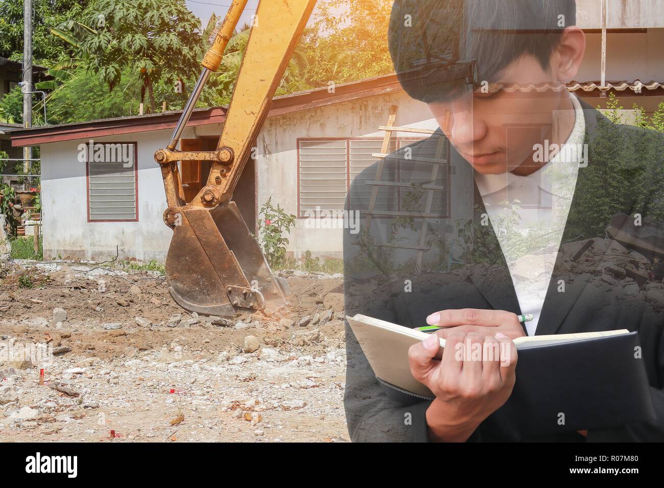 businessman with notepad in hand signing documents in construction site ...