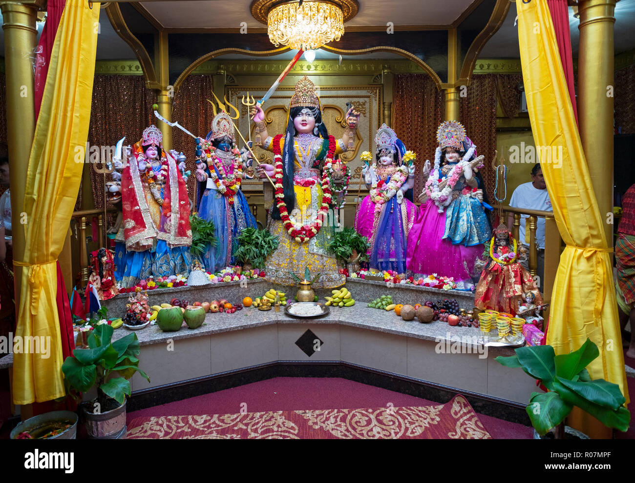 The altar at a Hindu temple in Queens with several statues of deities ...