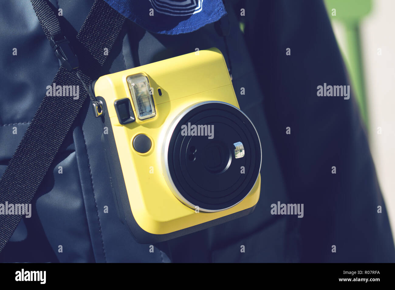 horizontal closeup of child with dark blue vest holding a yellow ...