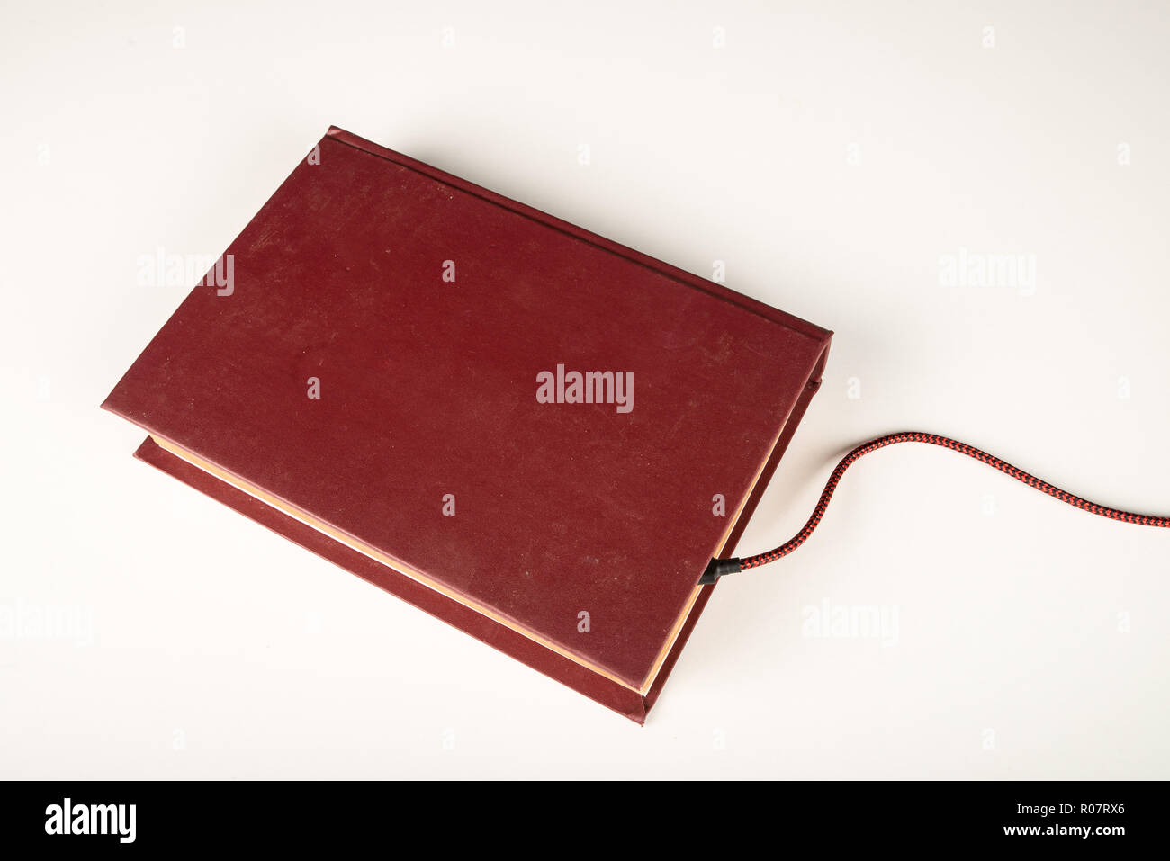 Old book with a battery charging cable, a concept of analog versus ...