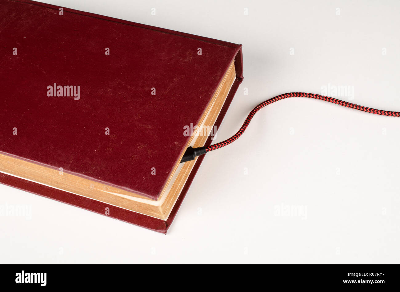 Old book with a battery charging cable, a concept of analog versus ...