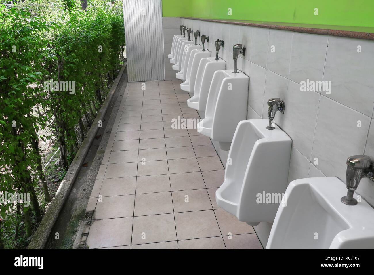 row of outdoor urinal men public toilet white urinals in men bathroom ...